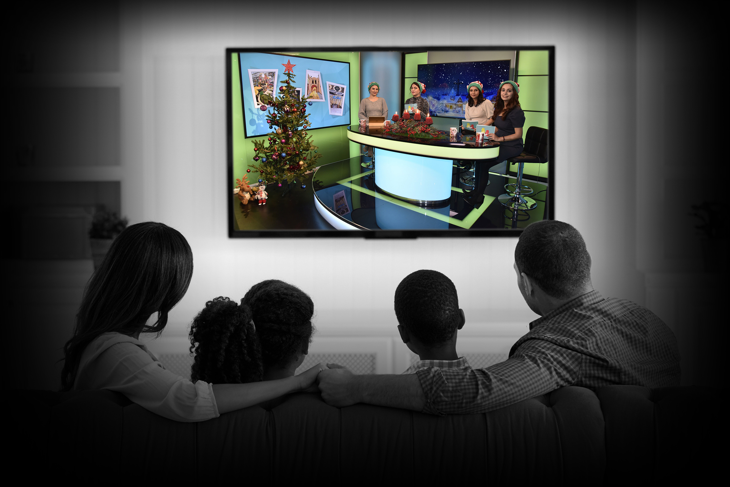 Parents and their two children watching TV together at home » SAT-7 UK